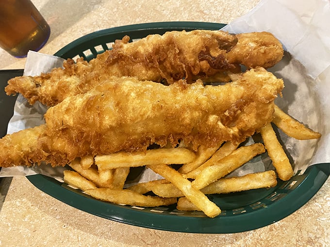 Golden-battered fish fillets perched atop a bed of crispy fries—this isn't just fish and chips, it's edible sunshine that crunches.