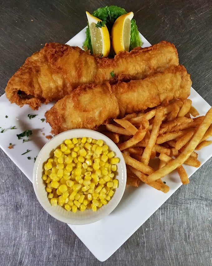 Golden-battered fish that shatters with each bite, served alongside crispy fries and sweet corn. This isn't just food—it's edible sunshine on a plate.