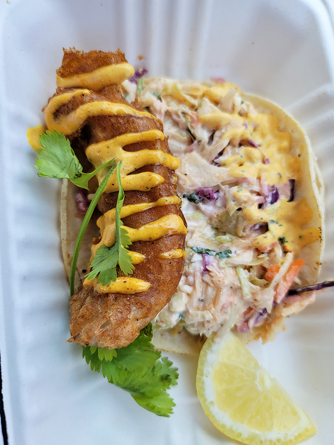 This fish taco isn't just food—it's edible proof that barbecue joints can master seafood too, especially with that perfect drizzle of sauce.