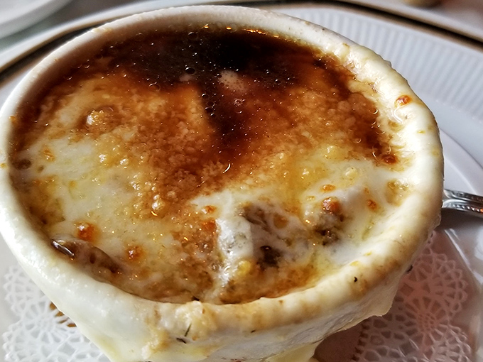 The legendary French onion soup arrives like a bubbling cauldron of comfort – that cheese pull should have its own Instagram account.