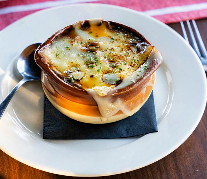 This isn't just French onion soup—it's a masterpiece of bubbling cheese, rich broth, and bread that's soaked up decades of culinary wisdom.