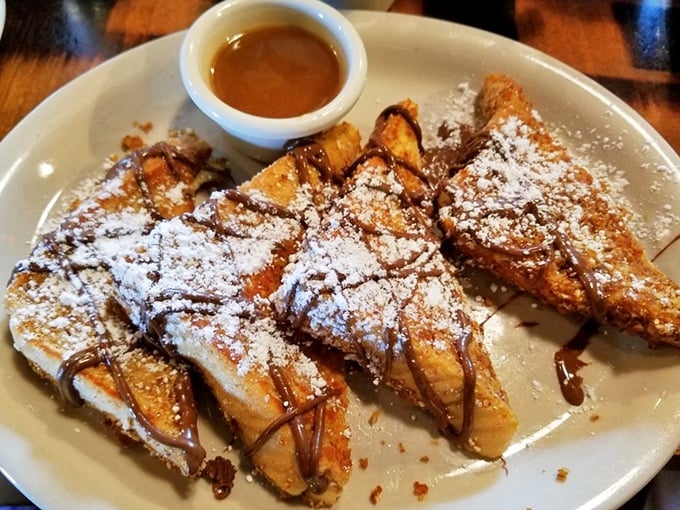 Golden-brown French toast dusted with powdered sugar and drizzled with chocolate—proof that sometimes the simplest pleasures are worth crossing state lines for.