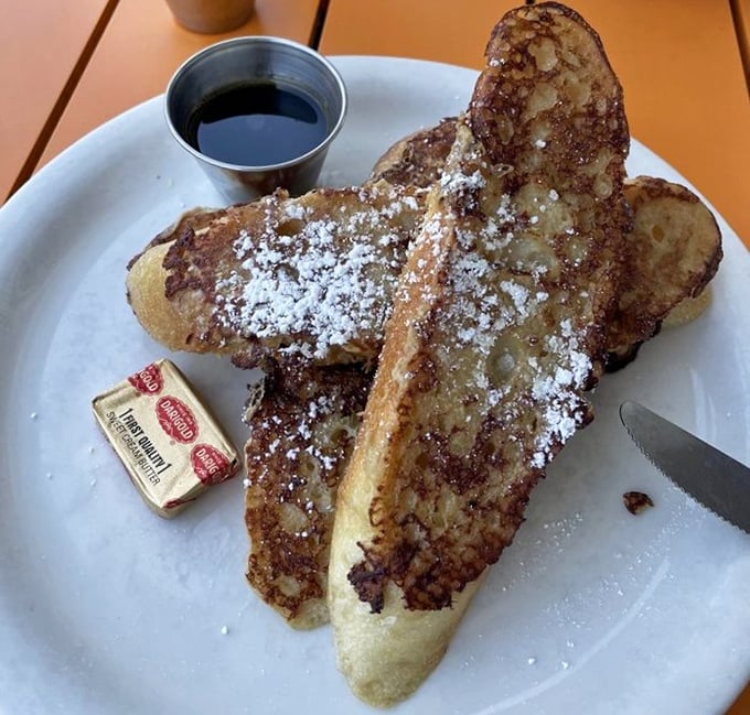 This isn't just French toast—it's a masterclass in breakfast perfection. Golden, crispy exterior giving way to custardy heaven, dusted with powdered sugar like fresh snow.