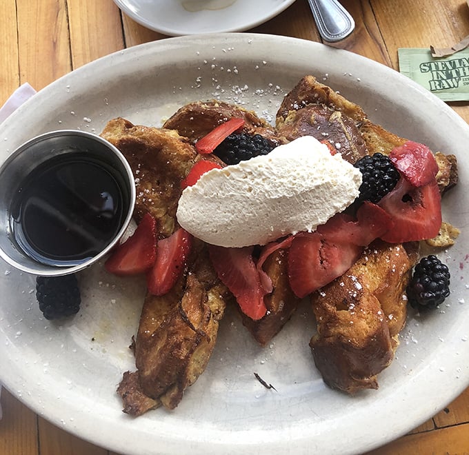 This French toast doesn't just arrive at your table – it makes an entrance, crowned with berries, whipped cream, and the silent question: "Why don't you eat like this every day?"