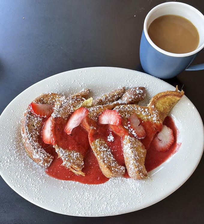 French toast nirvana achieved! Golden-brown perfection topped with fresh strawberries and a dusting of powdered sugar that would make angels weep with joy.