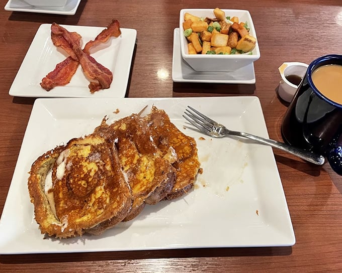 This French toast isn't just breakfast, it's an event—golden-brown perfection flanked by crispy bacon and home fries that demand attention.