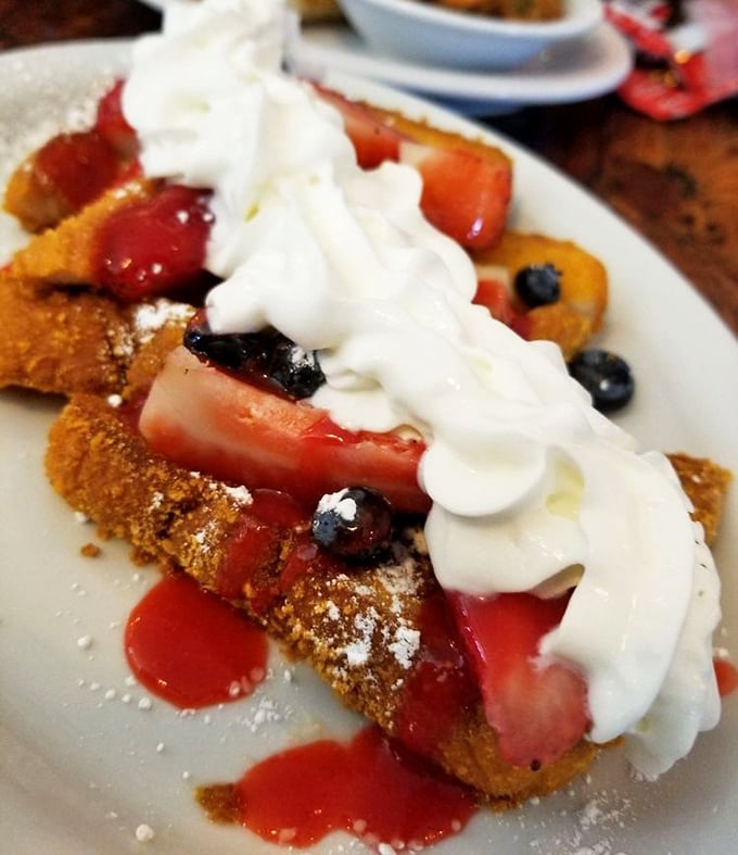This isn't just French toast – it's a berry-crowned masterpiece with enough whipped cream to make your cardiologist wince and your taste buds applaud.