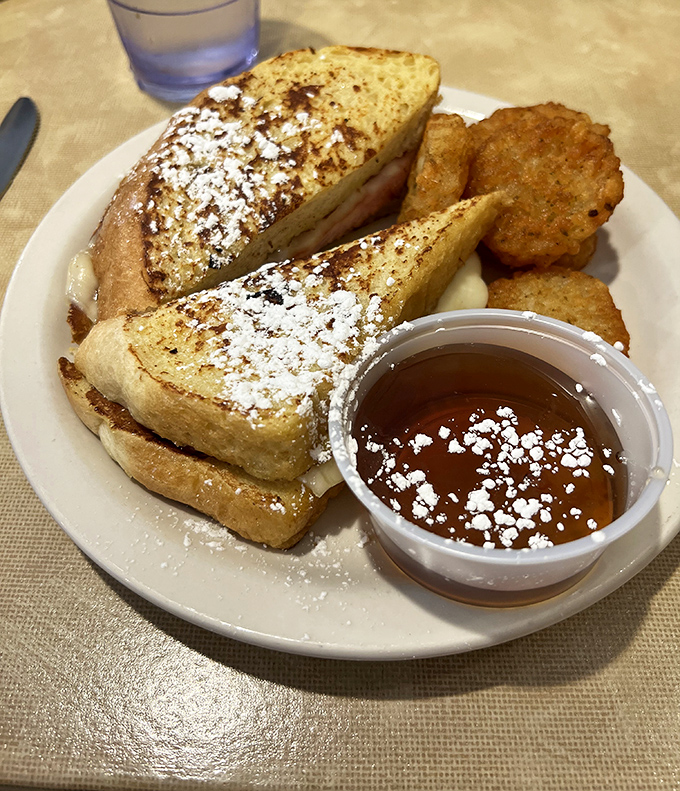 Golden-brown French toast dusted with powdered sugar that melts on contact—this isn't breakfast, it's edible therapy. Those potato cakes aren't just sidekicks; they're co-stars.