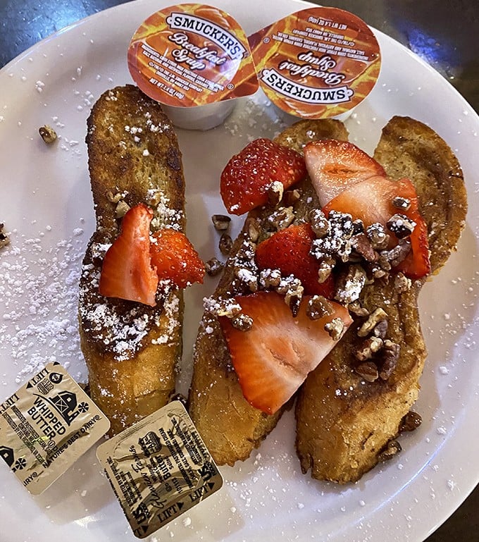 This isn't just French toast – it's a breakfast masterpiece with fresh strawberries and a dusting of powdered sugar that would make Michelangelo weep.