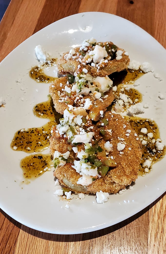 These aren't just fried green tomatoes—they're edible Southern postcards, complete with crumbled cheese and a sauce worth bottling.