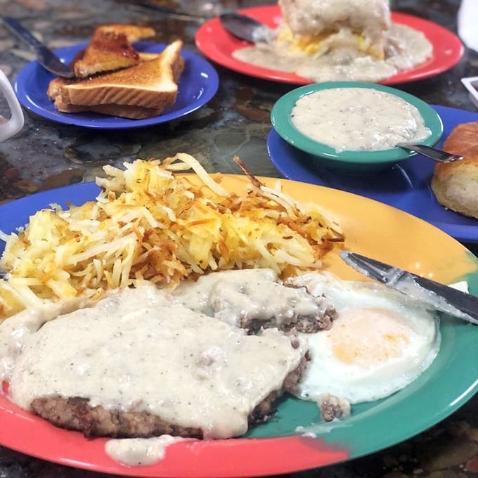 The legendary chicken fried steak in all its glory—tender meat under crispy breading, smothered in pepper gravy alongside golden hashbrowns. Pure bliss!