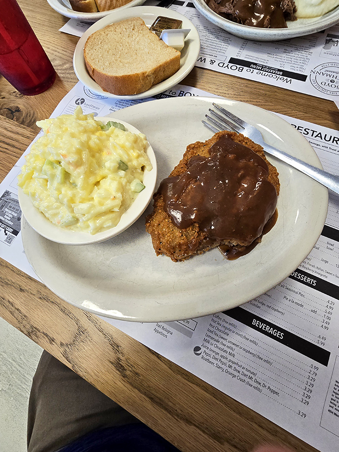 Country fried steak smothered in gravy alongside creamy macaroni salad—a plate that whispers, "Your diet starts tomorrow, and we both know it."