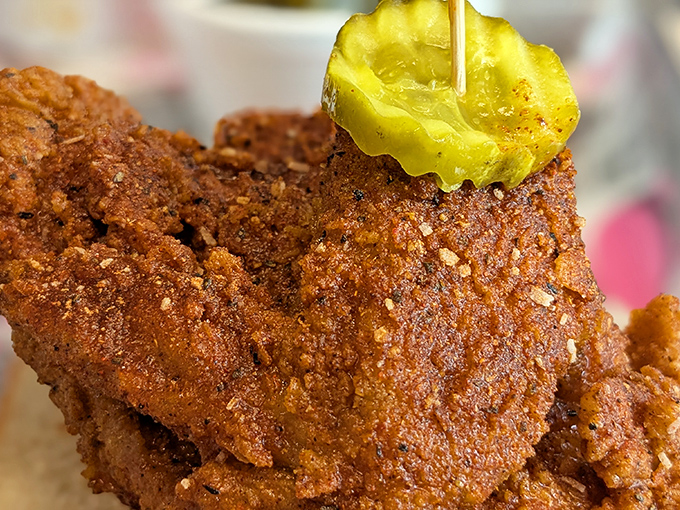 That perfect golden-brown crust with a pickle perched on top—this isn't just fried chicken, it's edible architecture with attitude.