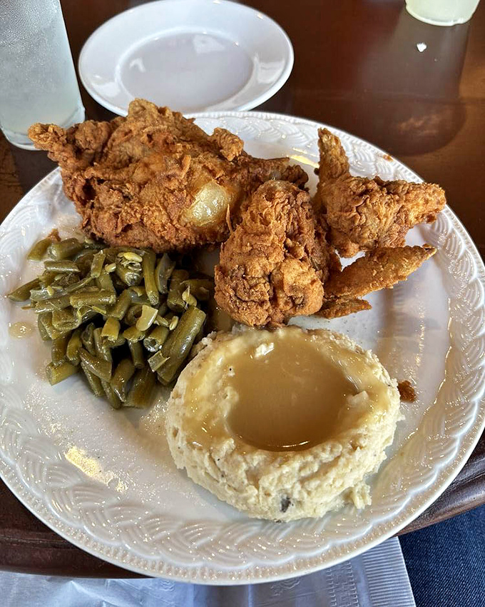 Golden-crusted perfection arrives with green beans that still have backbone and mashed potatoes worthy of their gravy crown.