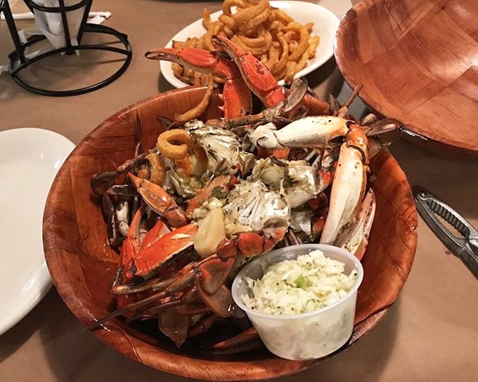 Behold the wooden bowl of glory—garlic crabs piled high like edible treasure from Neptune's personal stash.