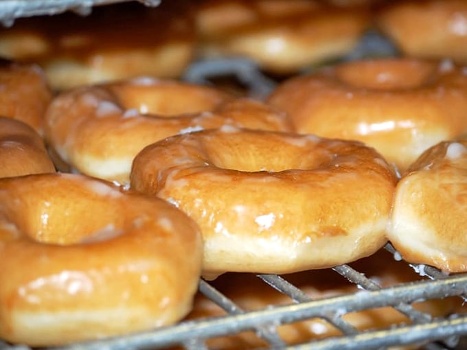 Fresh glazed donuts glistening under the bakery lights. That perfect sheen isn't just for show—it's nature's way of saying "eat me immediately."