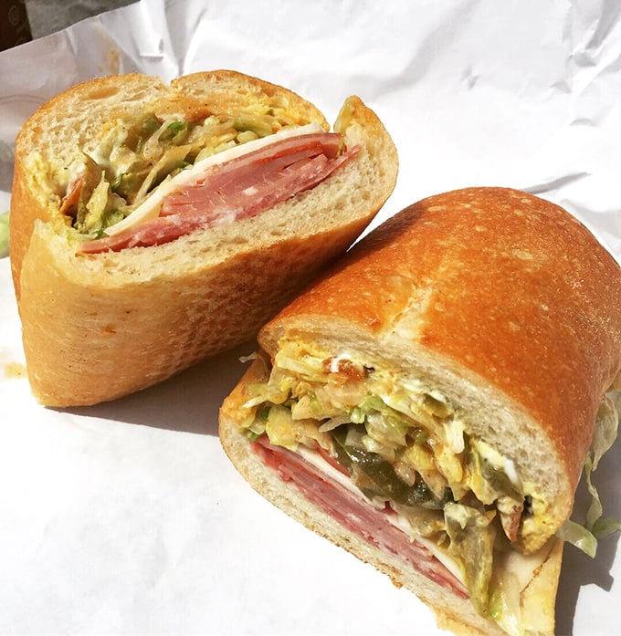 The legendary Godmother sandwich, sliced to reveal its magnificent layers—a cross-section of perfection that belongs in the Louvre of Lunch.