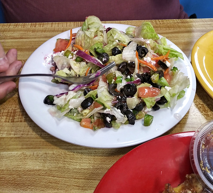 Behold the legendary Greek salad—a symphony of crisp lettuce, briny olives, and feta cheese that would make Zeus himself weep with joy.