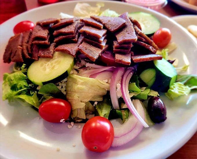 This isn't just any Greek salad – it's a masterpiece of crisp vegetables, briny olives, and generous gyro meat that would make Zeus himself weep with joy.