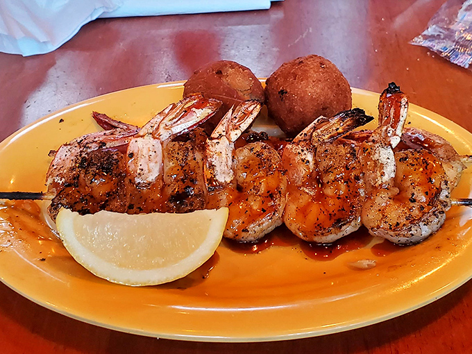 Perfectly grilled shrimp skewers with a hint of char, accompanied by golden hushpuppies and a lemon wedge – simplicity that lets the Gulf's bounty shine.