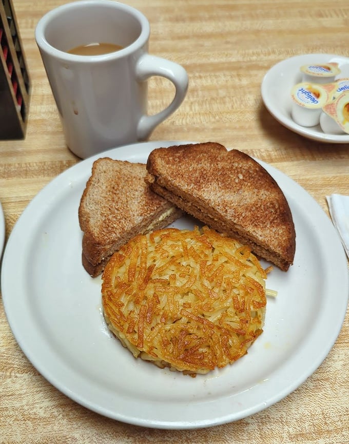 The star of the show: perfectly crispy hash browns alongside a sandwich. This golden-brown potato disc isn't just a side—it's the main event that justifies the journey.