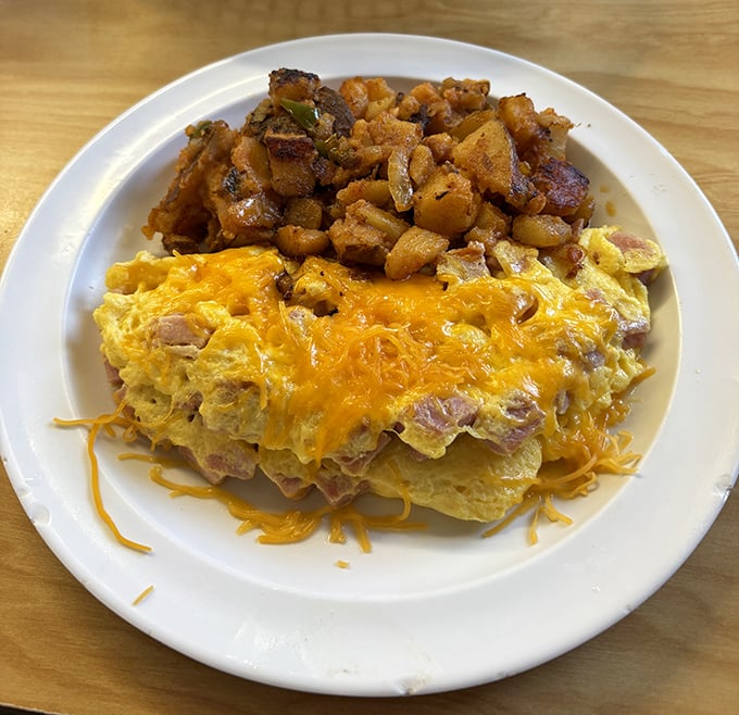 Behold: the ham and cheese omelet that launched a thousand food dreams. Those potatoes aren't side characters—they're co-stars in this breakfast blockbuster.