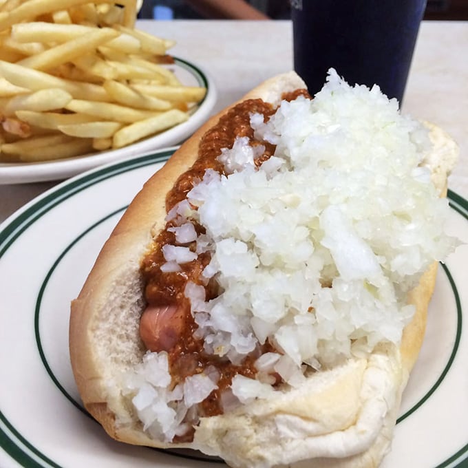 Hot dog royalty in its most authentic form—crowned with a mountain of diced onions and that legendary meat sauce that's worth every napkin.