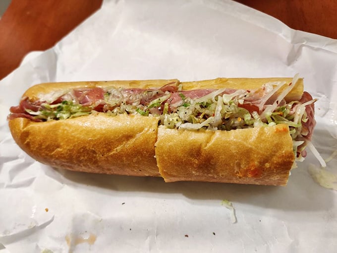 Behold the Italian hoagie in all its glory—layers of thinly sliced meats, crisp vegetables, and that perfect oil drizzle creating edible architecture.