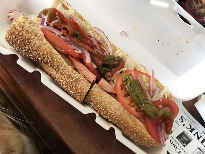 Sesame-seeded roll, vibrant veggies, and layers of Italian meats create a sandwich architecture that would make Frank Lloyd Wright weep with joy.