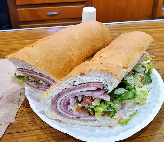 Behold the Italian hoagie in its natural habitat—layers of meat and fresh toppings that require both hands and possibly a strategic eating plan.