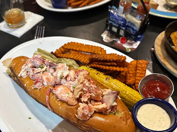 Not just a sandwich but a celebration – this lobster roll bursts with sweet meat nestled in a buttery vessel, flanked by crispy waffle fries and corn.