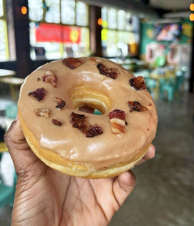 The legendary maple bacon donut in all its glory—where maple glaze meets perfectly crispy bacon bits in a harmony sweeter than The Beatles' greatest hits.