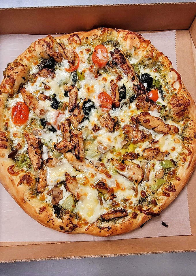 This isn't just pizza – it's a masterpiece of chicken, pesto, and roasted tomatoes that would make an Italian art restorer weep.