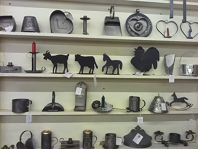 Metal farm implements and folk art silhouettes line these shelves—practical tools from yesterday that have become today's rustic decor statements.