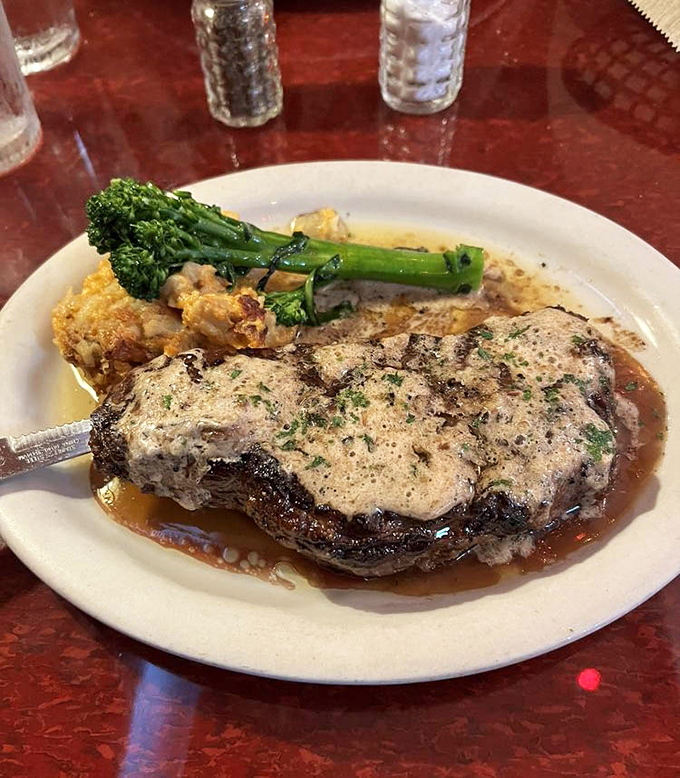 A perfectly seared steak swimming in buttery demi-glace that would make Julia Child weep with joy. The broccoli is just there to ease your conscience.