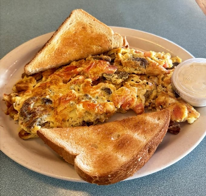 This isn't just an omelet; it's a masterclass in breakfast architecture. Golden exterior, perfectly melted cheese, and enough fillings to make each bite a new adventure.