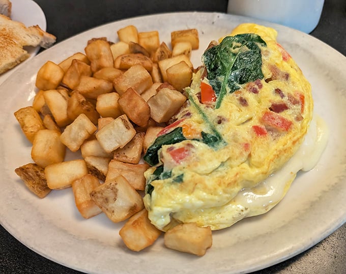 Behold the Florentine Omelet in its natural habitat—perfectly fluffy, bursting with spinach and cheese, flanked by an army of golden home fries.
