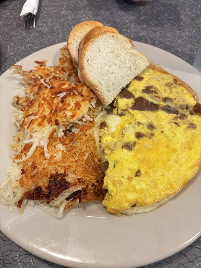 Behold the star of the show—a perfectly executed omelette with crispy hash browns that would make any breakfast aficionado weak at the knees.