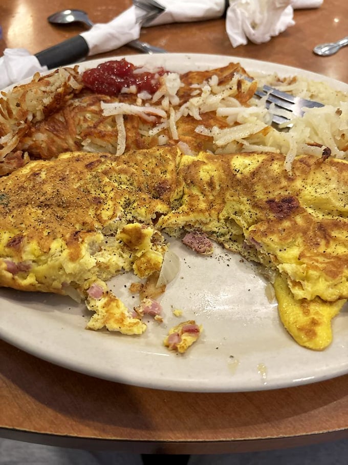 Egg architecture at its finest! This golden omelette with perfectly distributed fillings sits beside crispy home fries—a breakfast duet worth crossing the Schuylkill for.