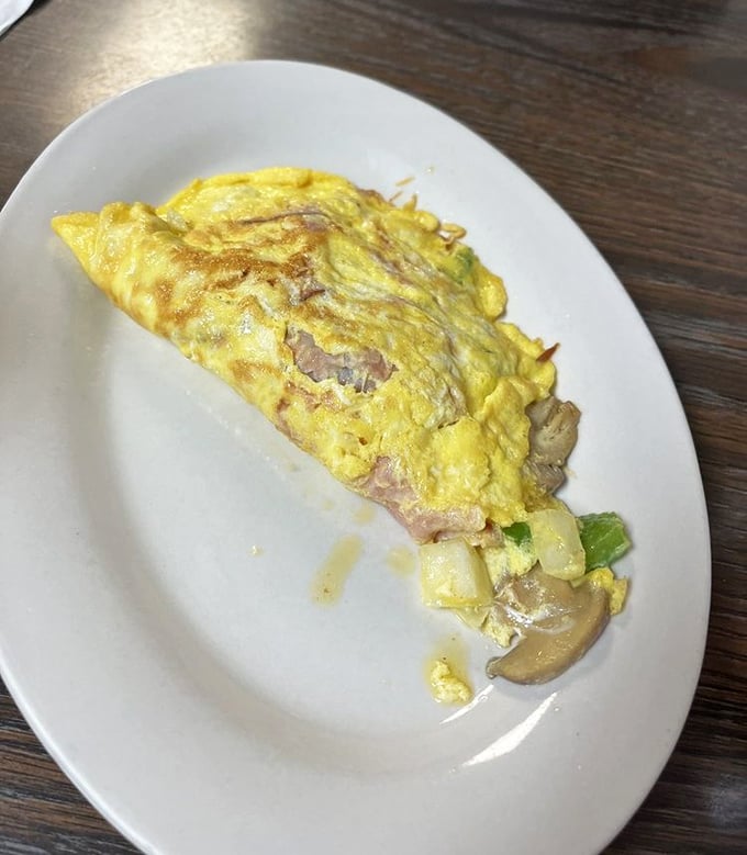 This isn't just an omelet—it's a golden envelope delivering a love letter of mushrooms and cheese to your taste buds.