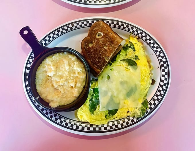 This isn't just an omelet—it's a golden envelope of possibility, stuffed with fresh vegetables and served with grits that would make any Southerner proud.