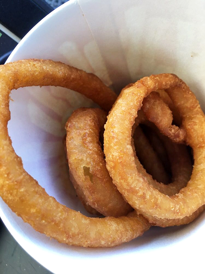 Golden halos of fried perfection—these onion rings achieve that mythical balance between crispy exterior and sweet, tender interior that makes you forget vegetables are supposed to be healthy.