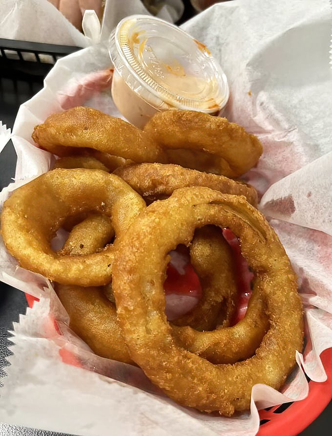 Golden halos of perfection—these aren't just onion rings, they're crispy, hand-battered masterpieces that could make a food critic weep with joy.