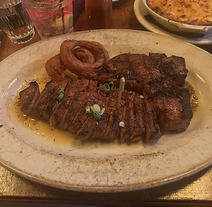 Behold the star of the show: a perfectly seared ribeye that's been pampered more than most celebrities, complete with a crispy onion ring crown.