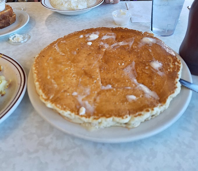 This pancake isn't just big—it's the solar system of breakfast foods, with butter creating its own delicious melt zone in the center.