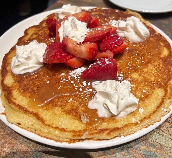 Behold the strawberry-crowned pancake masterpiece that transforms ordinary mornings into something worthy of a standing ovation.