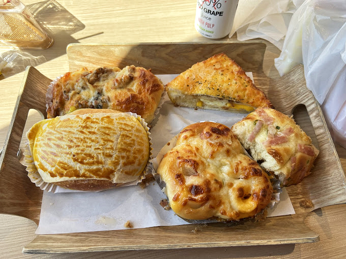 A wooden tray of pastry perfection that makes you wonder if you should take a photo first or just surrender to immediate consumption.