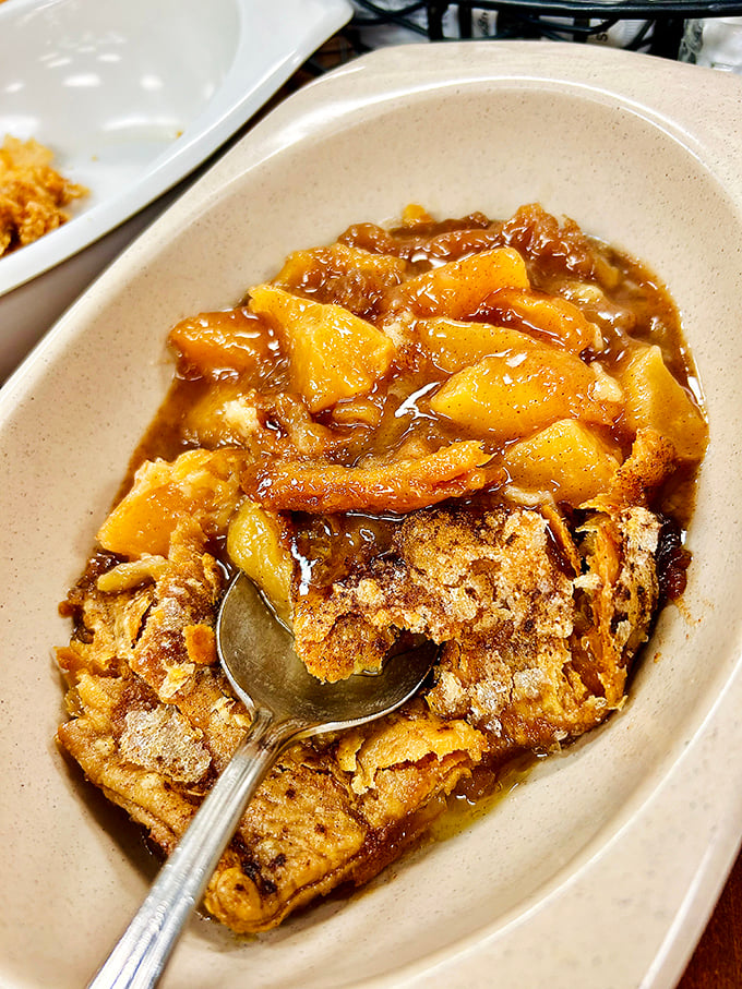 Behold the holy grail—peach cobbler that makes time stand still, with golden Georgia peaches swimming in a buttery bath beneath that perfect crust.