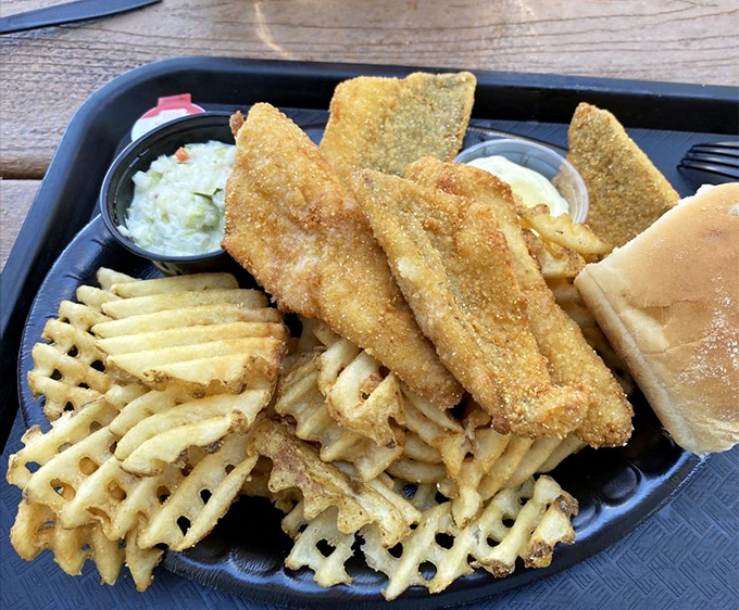 Golden-fried perch fillets nestled atop waffle fries with a side of coleslaw – a holy trinity of Great Lakes cuisine that demands reverent silence between bites.