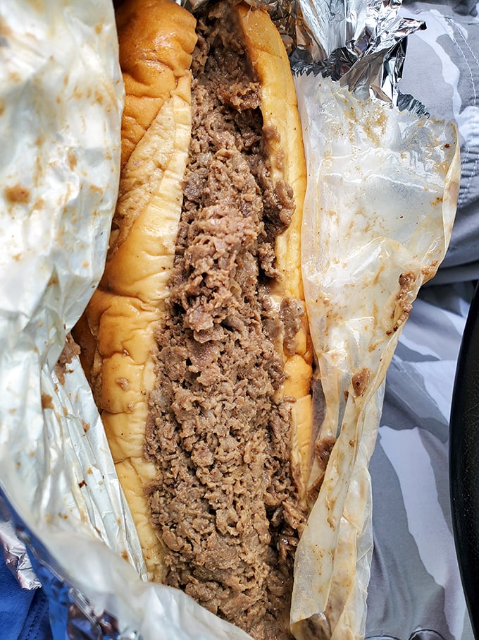 Behold the star attraction – thinly sliced ribeye packed into a perfect roll, the kind of cheesesteak that haunts your dreams.
